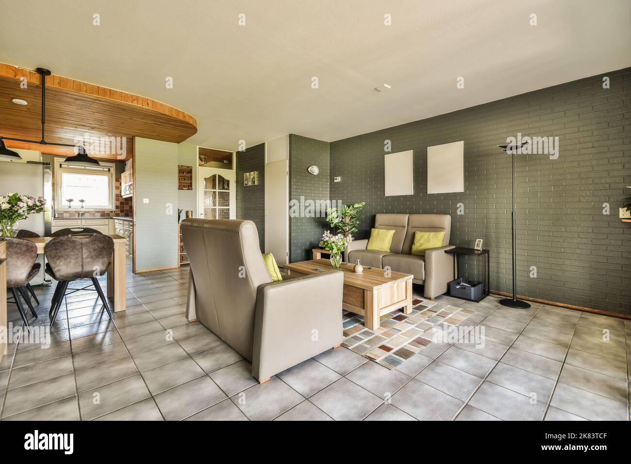 Table with chairs and flowers located near lounge area and kitchen in ...