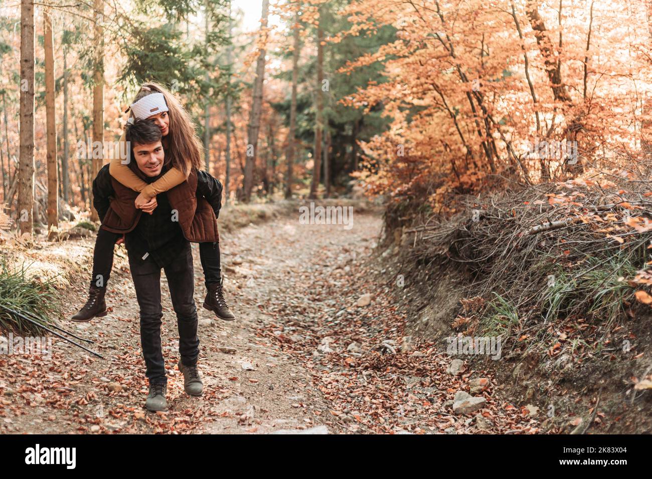 Young romantic couple in the woods. Piggyback riding. Happy together ...