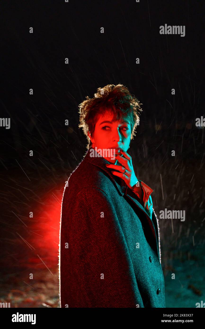 Frightened woman is freezing standing on street in snowy weather ...