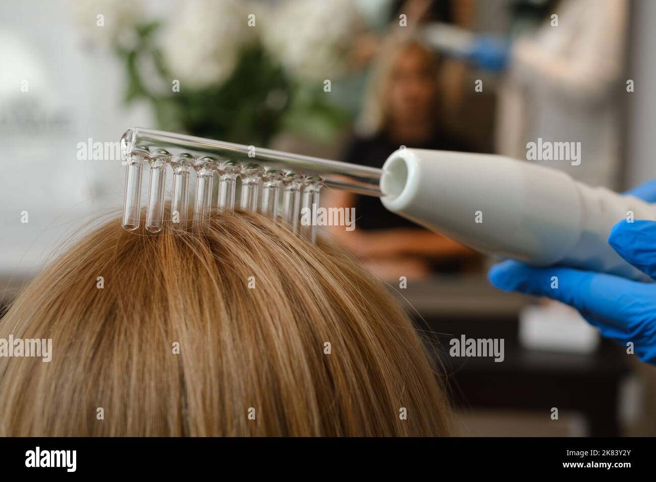 Doctor treats head skin with special dermatology equipment system ...