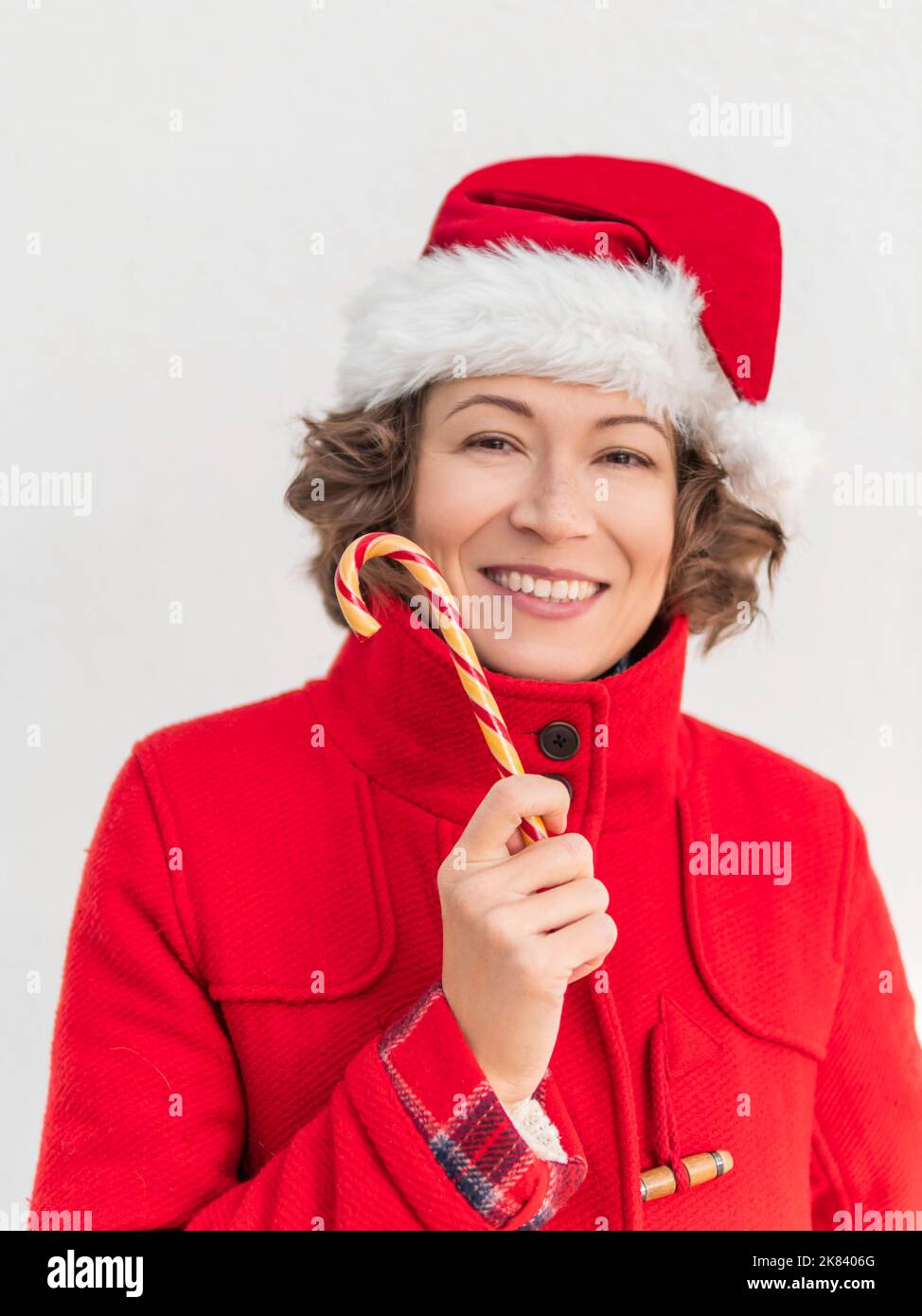 Curly winking woman with striped candy cane. Pretty female with ...
