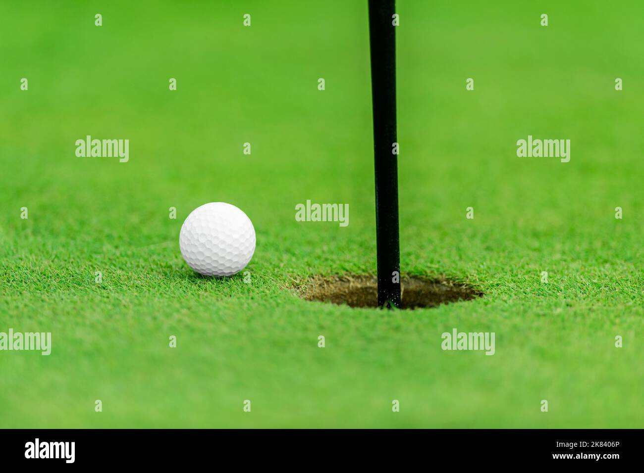 Flag, ball and hole at the beautiful golf course. Horizontal sport ...