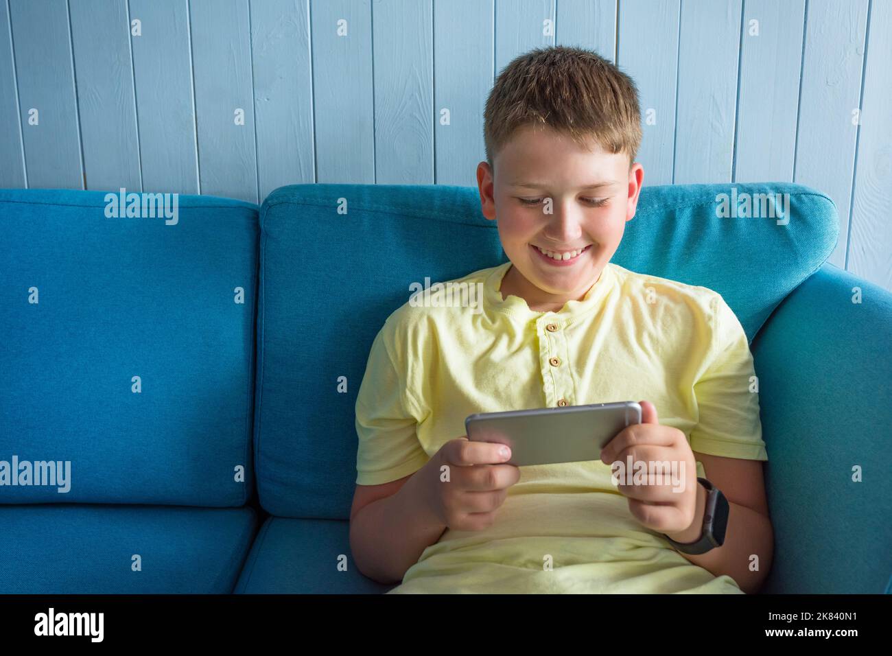 Portrait of a smiling boy with a smartphone in his hands. The child ...