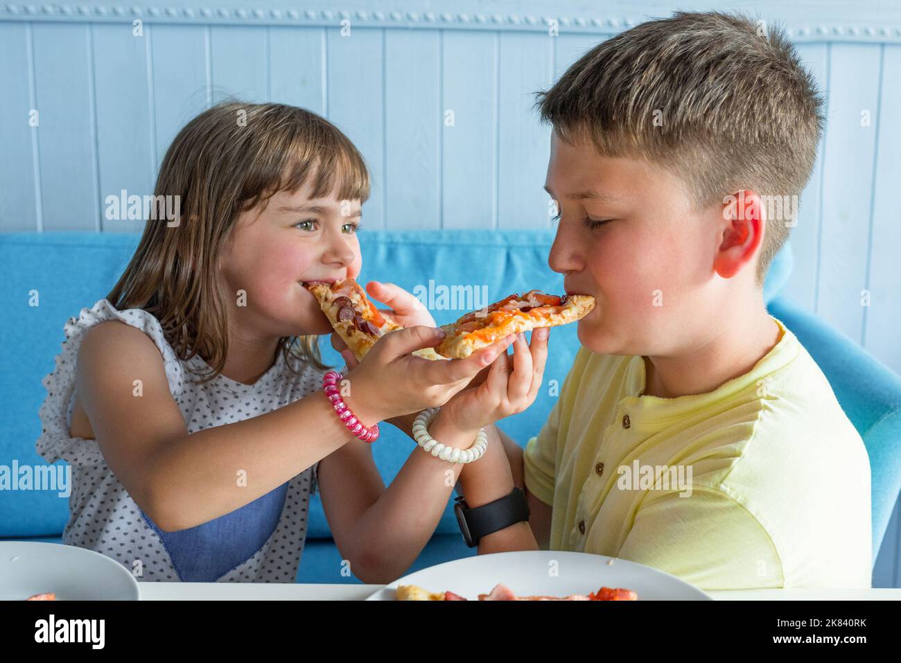 Kids eating pizza indoors. Fast food. Close-up Stock Photo - Alamy