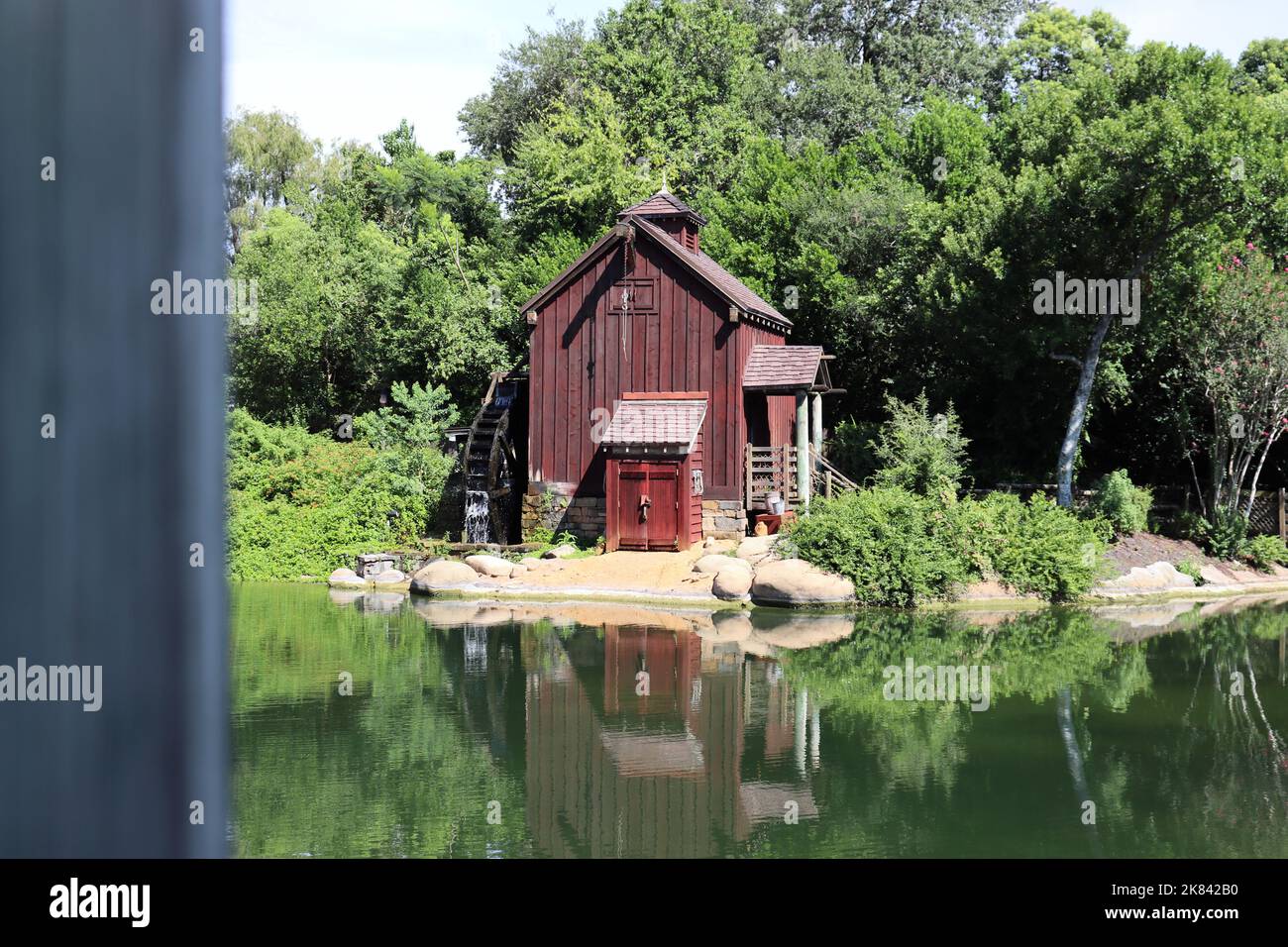 Water mill and a Barn reflection in the water surrounded by a forest ...