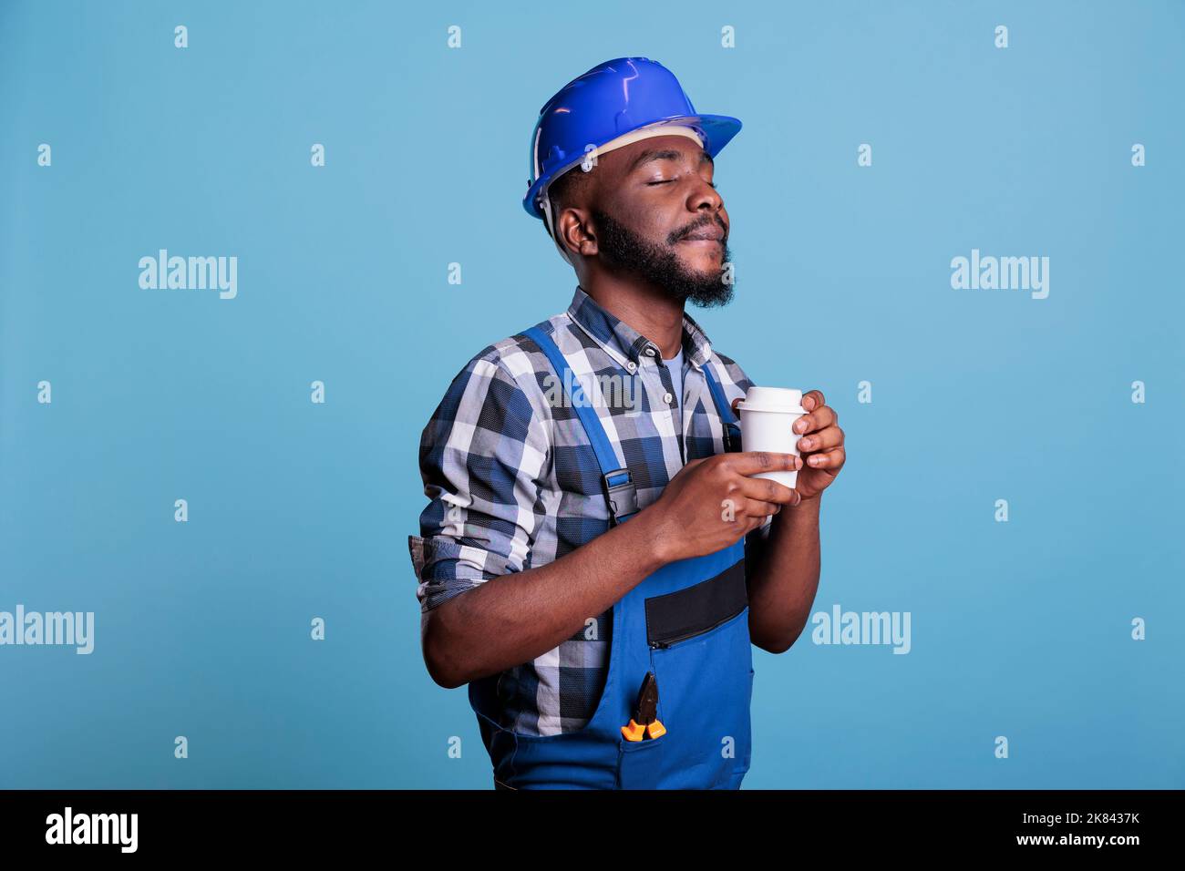 Relaxed construction worker enjoying a cup of favorite coffee before ...