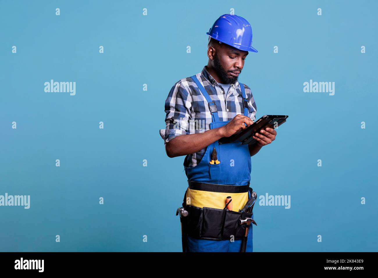 Portrait of a builder working with a digital tablet, shopping online ...