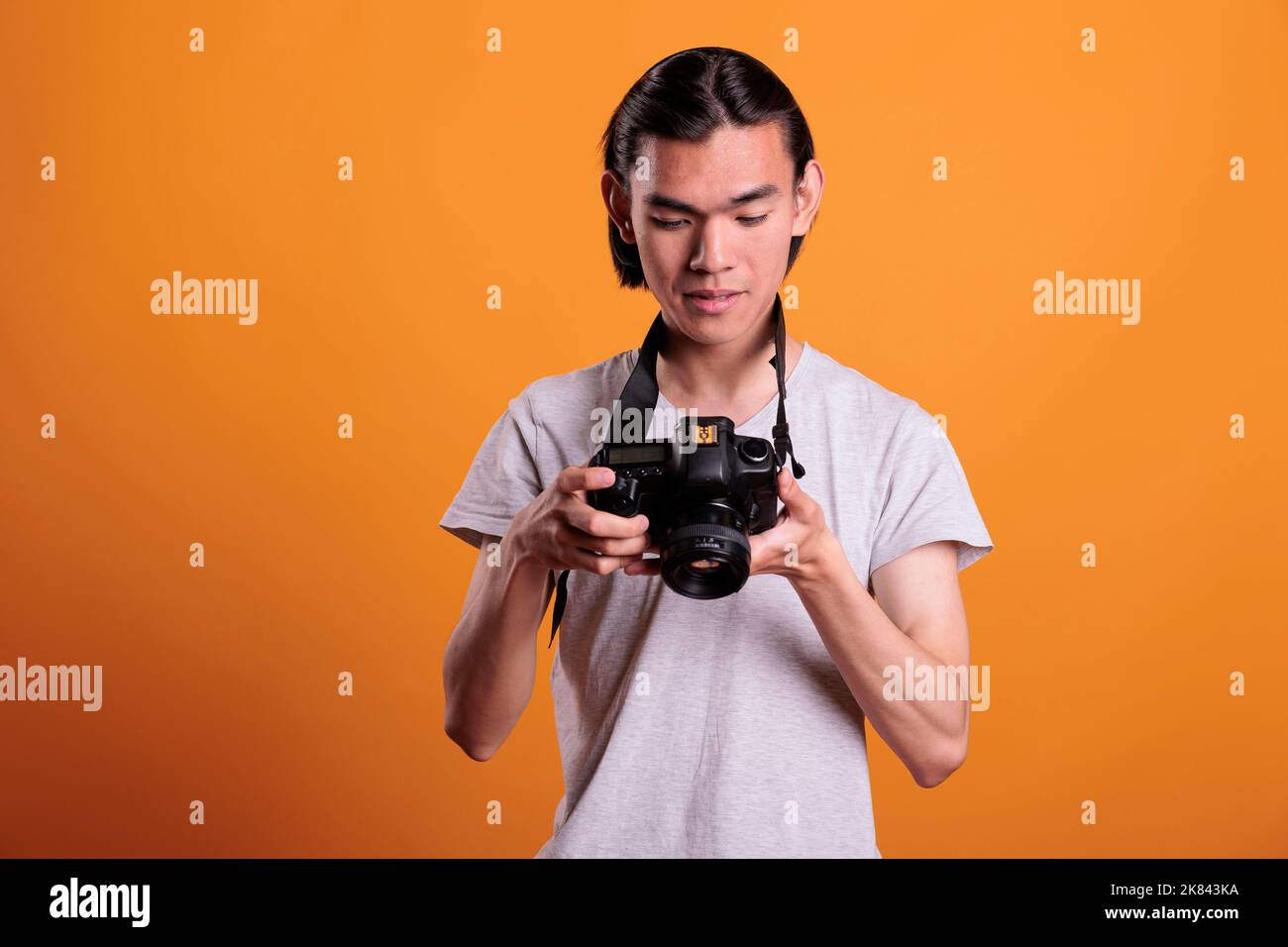 Young photographer taking photos on professional dslr camera, looking ...