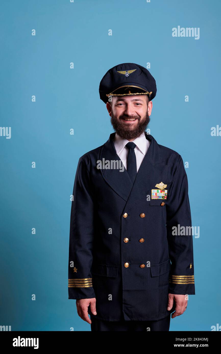 Portrait of airplane captain wearing aviation uniform and hat, plane ...