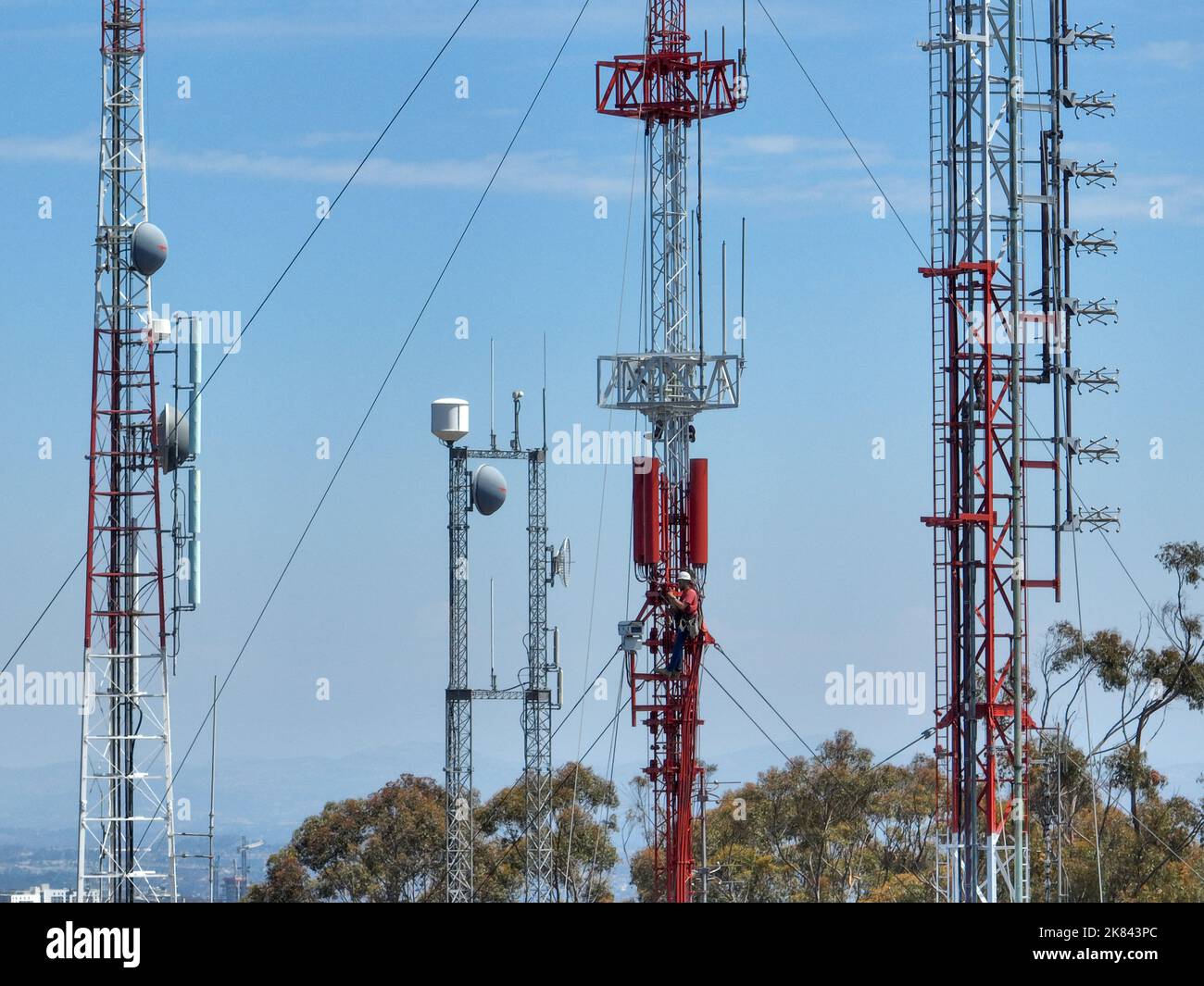 Engineer with safety equipment on high tower for working telecom ...