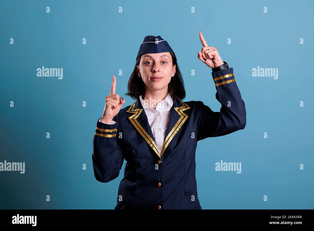 Stewardess pointing up with index fingers, aviation academy flight ...
