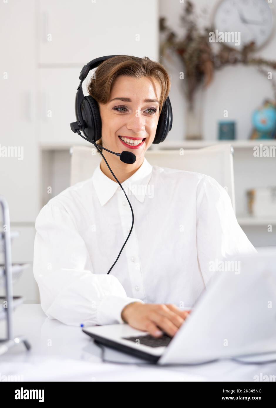 Female operator talking with customer using headset at company office ...
