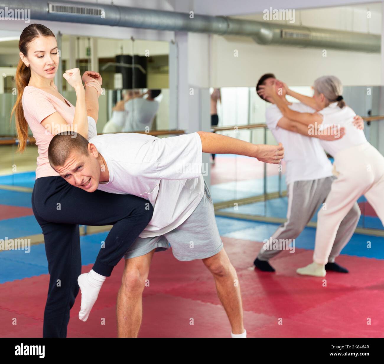 Girl practicing elbow and knee strikes with arm hold to male sparring ...