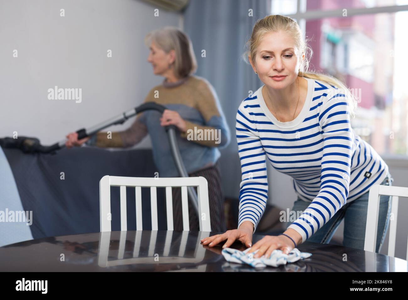 Woman cleaning table with rag Stock Photo - Alamy