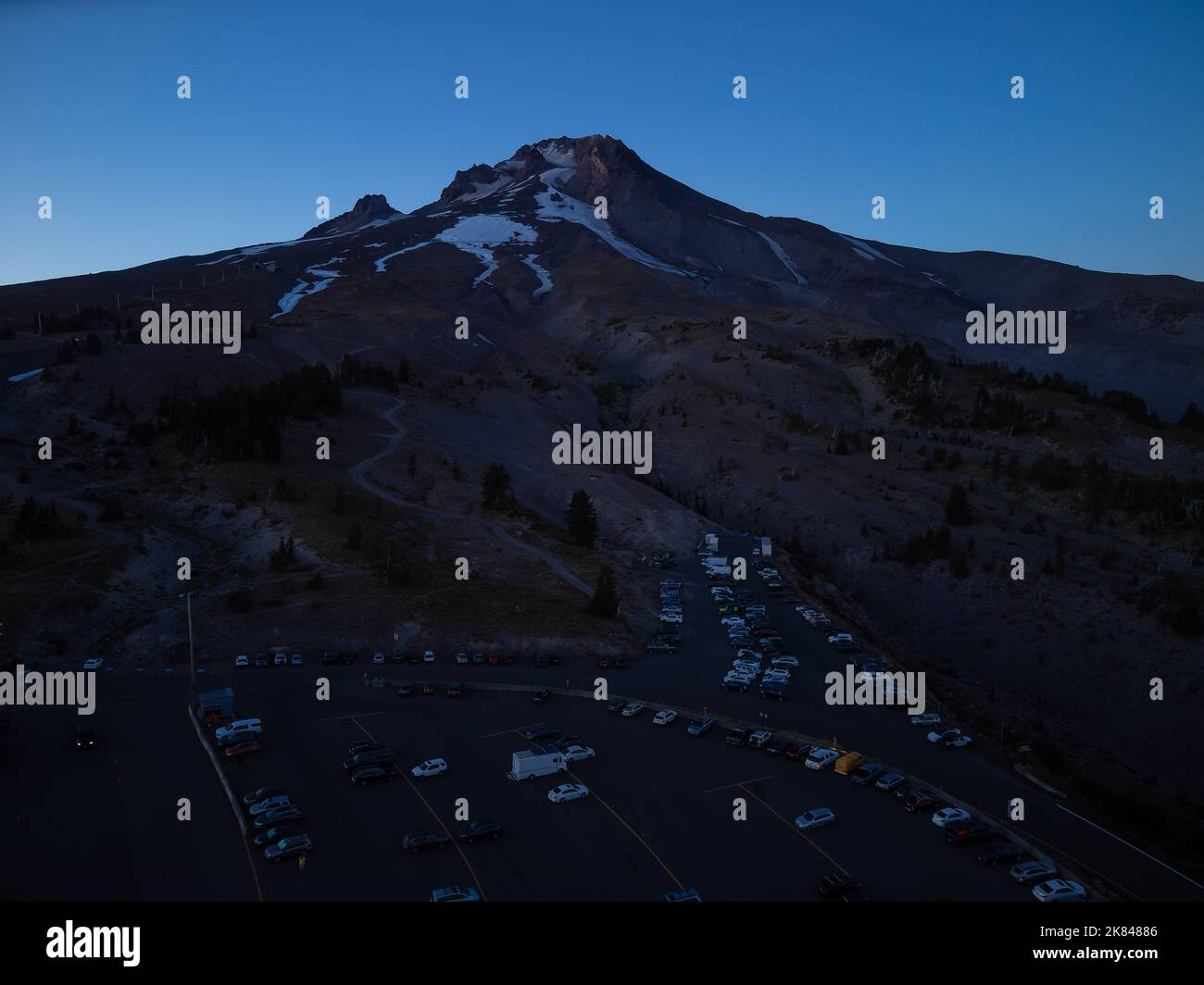 Beautiful landscape. Car parking at the foot of a high snow-covered ...