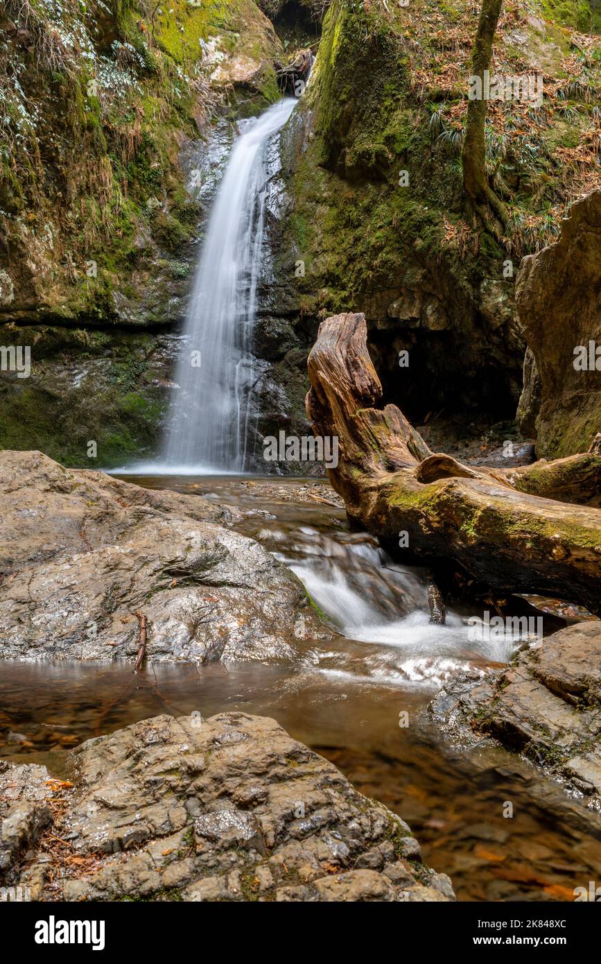 beautiful smooth white waterfall falling between moss covered rocks ...