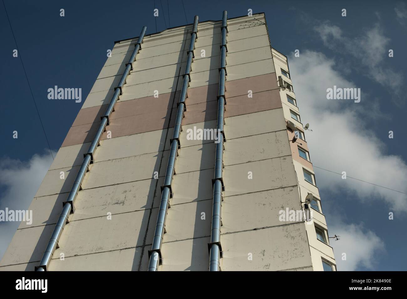 Pipes on wall of building. Heating pipes go up. Tall building ...