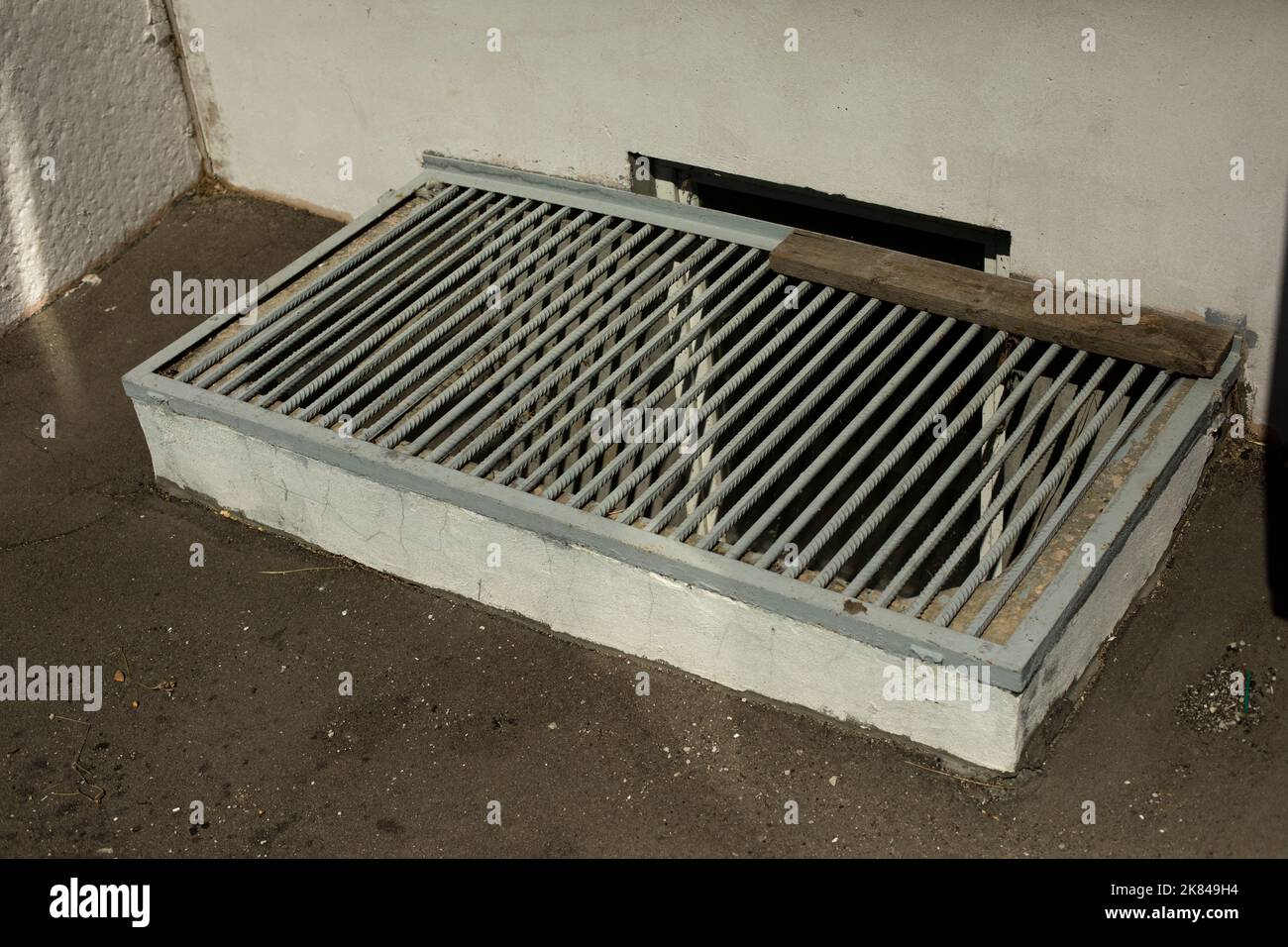 Basement opening in building. Grate on pit. Basement. Window below ...
