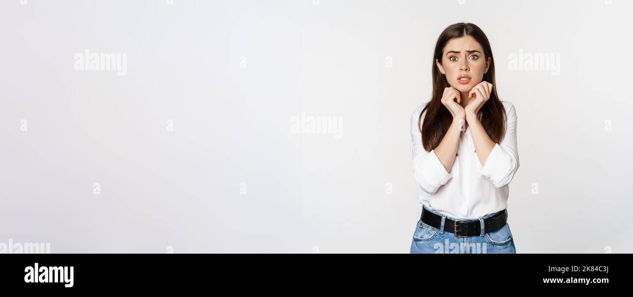 Portrait of brunette woman looking concerned, worried and shocked ...