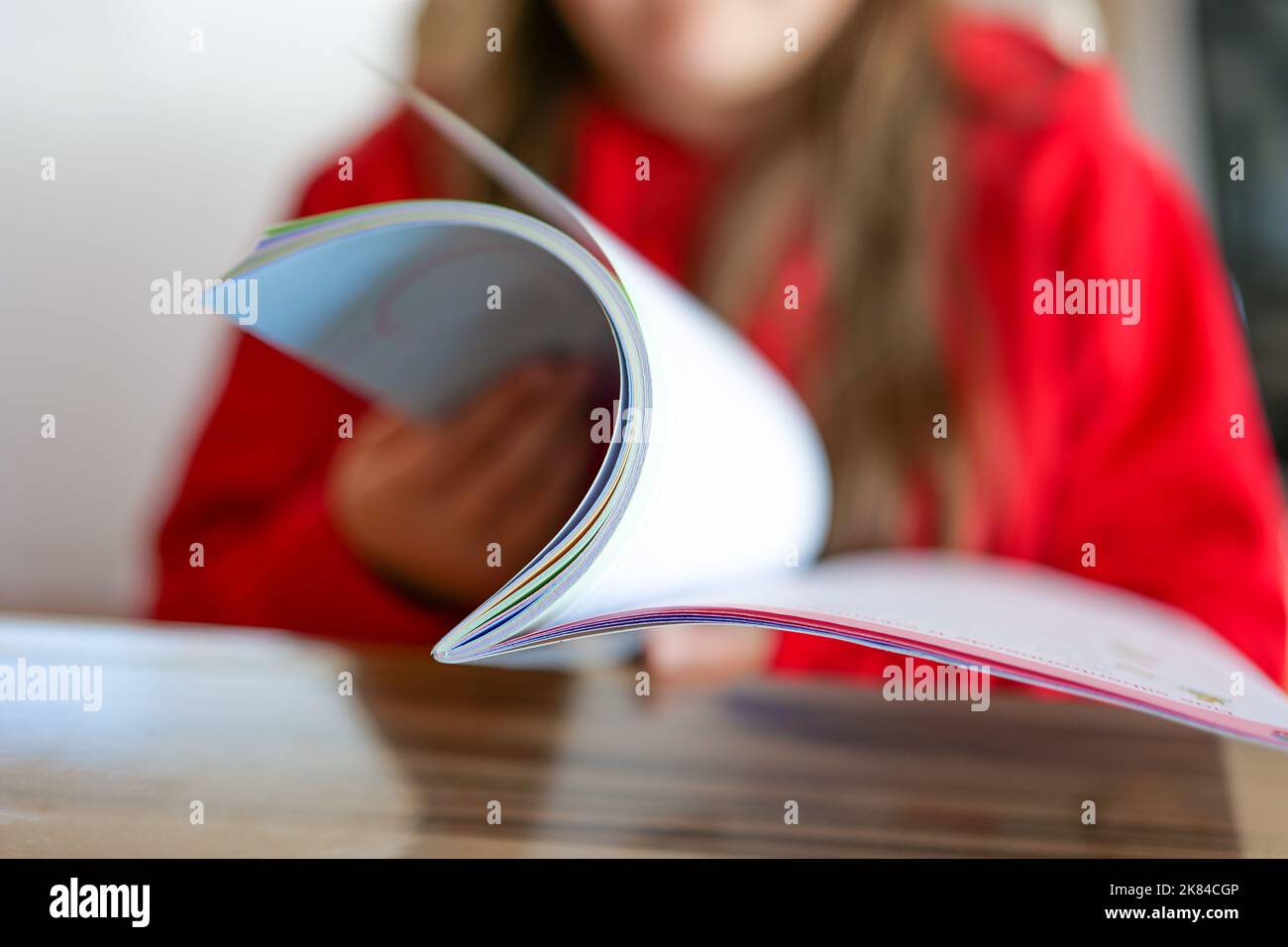 Homework.Girl in a sweatshirt with an open book. Soft focus. Study and ...