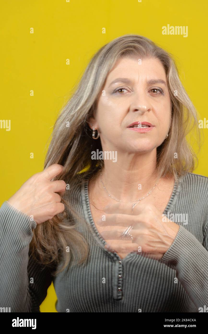 Beautiful model against yellow background. She wears gray colored ...
