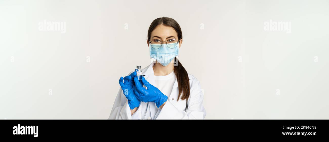 Portrait of young woman, doctor in medical face mask and uniform ...