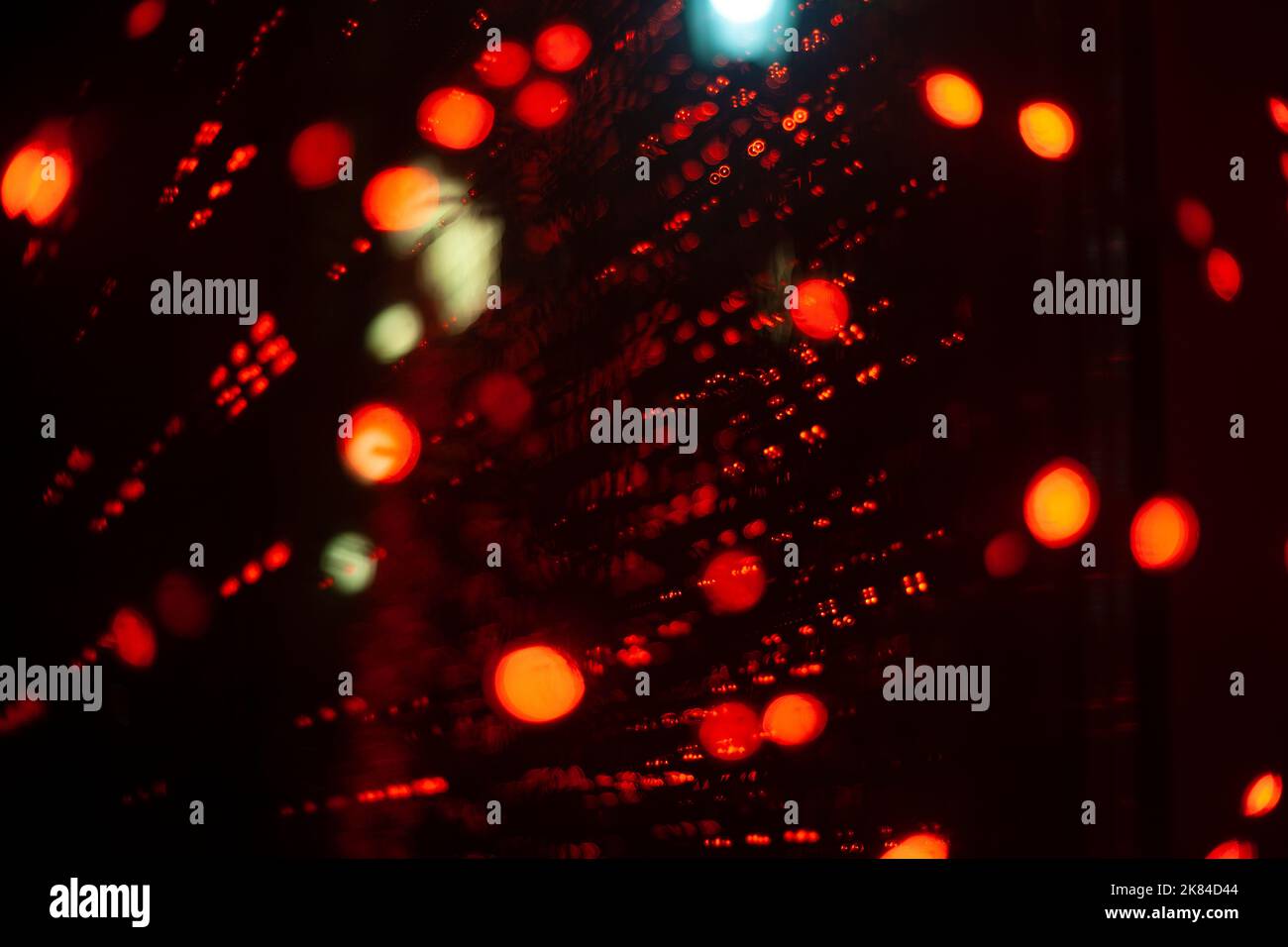 Red garland. Lights in dark. Window decoration details. Light on glass ...