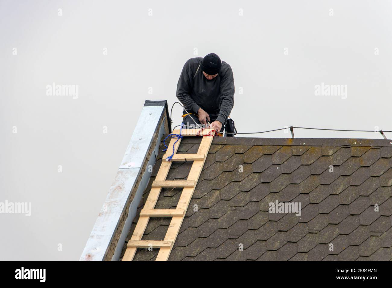 A repairman with a ladder is repairing the roof Stock Photo - Alamy