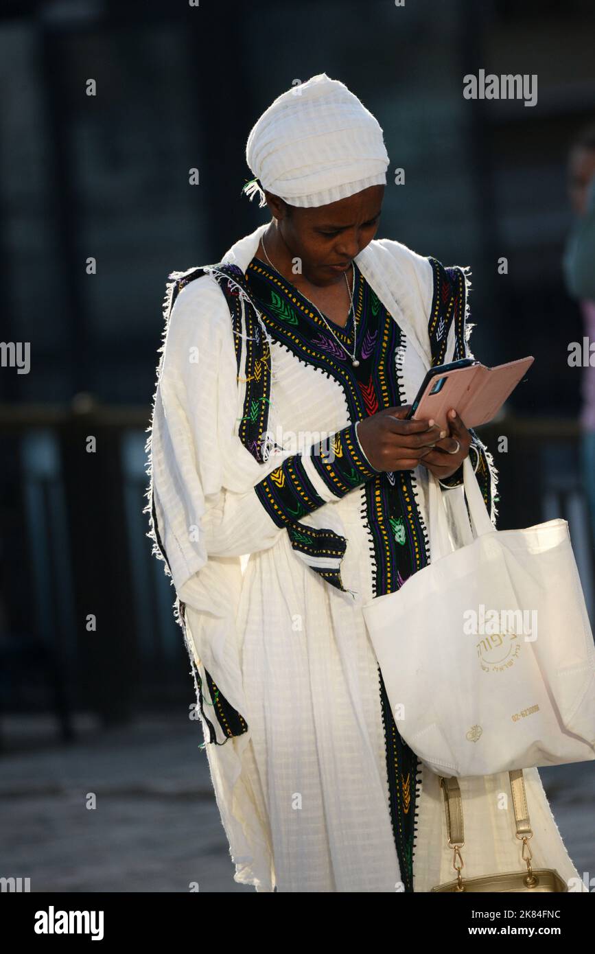 A colorfuly dressed Ethiopian-Israeli woman walking by the Wailing Wall ...