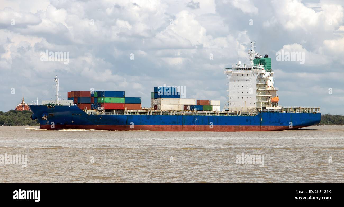 A container ship loaded with containers sails alongside the shore Stock ...