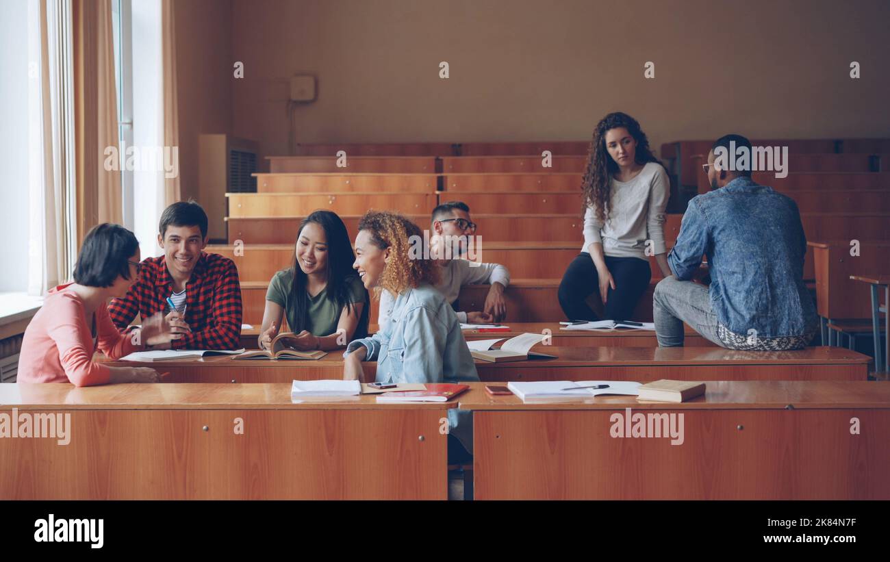 Young cheerful people are talking and relaxing during break between ...
