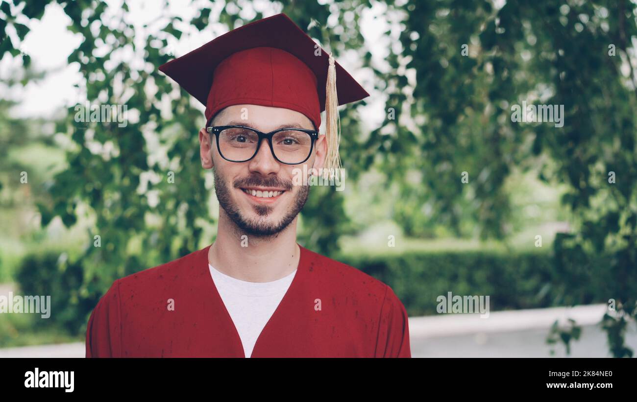 Portrait of bearded young man graduating student wearing glasses ...