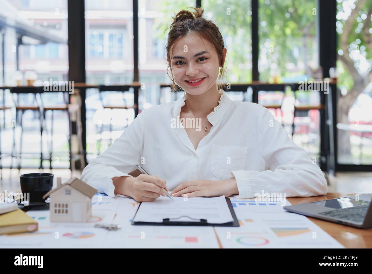Portrait of a beautiful bank young woman sign credit department of ...