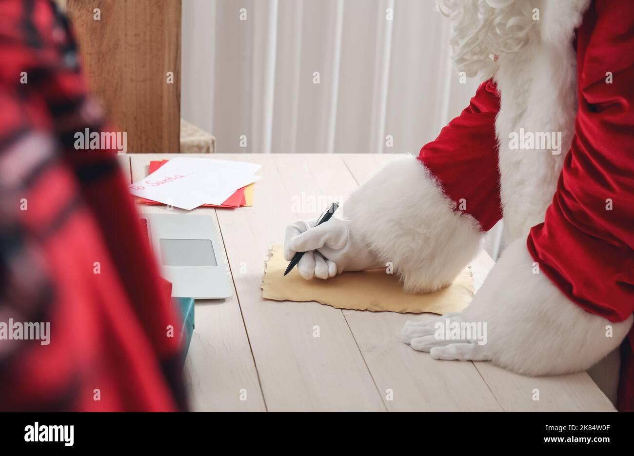 Santa Claus writing letter on wooden standing desk in room Stock Photo ...