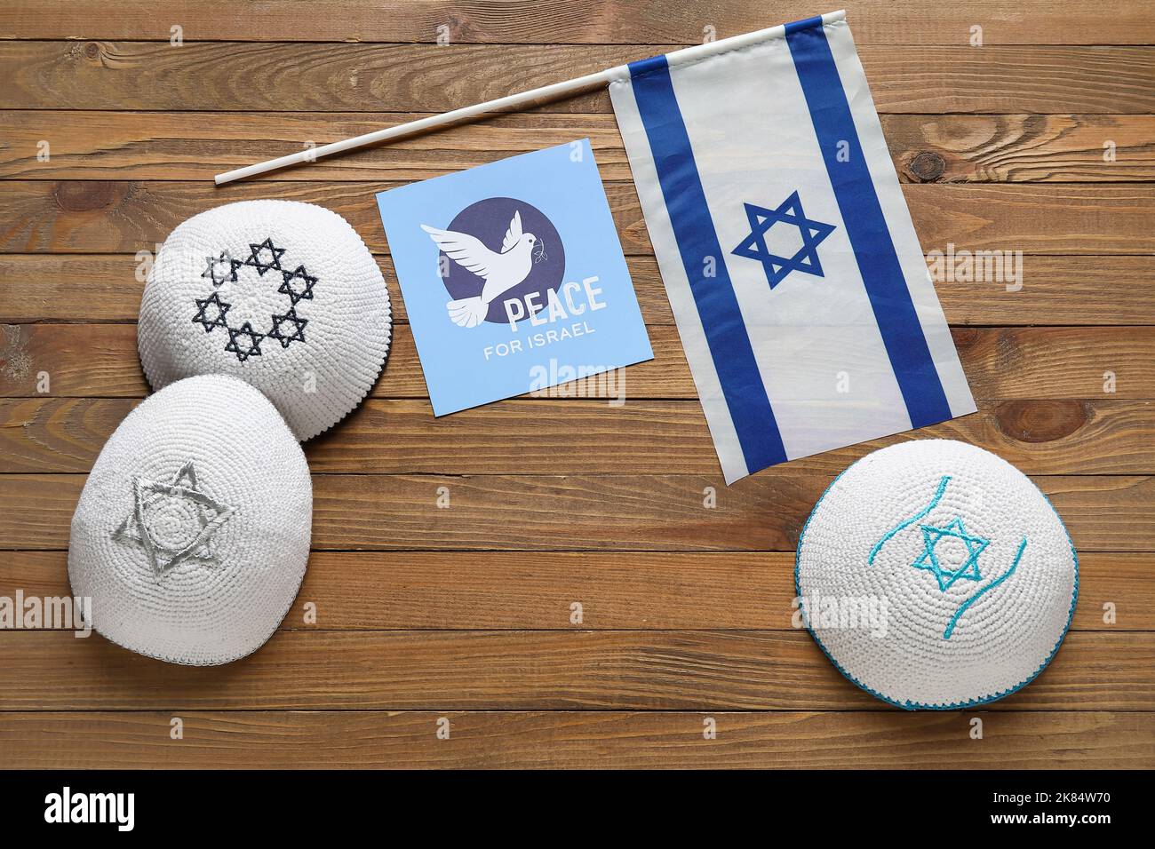 Kippahs, flag of Israel and card with text PEACE FOR ISRAEL on wooden ...