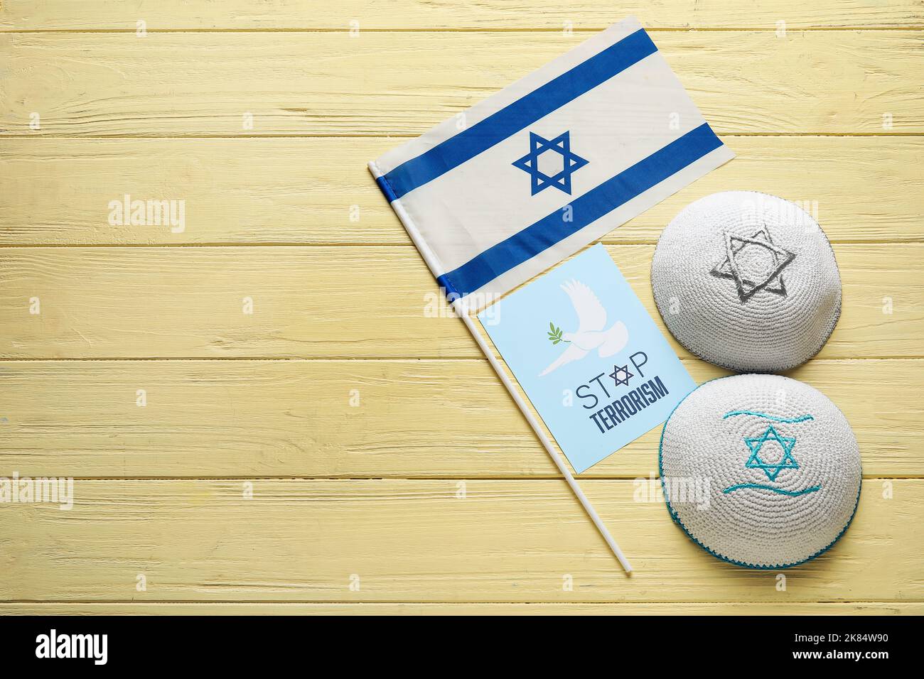 Kippahs, flag of Israel and card with text STOP TERRORISM on color ...