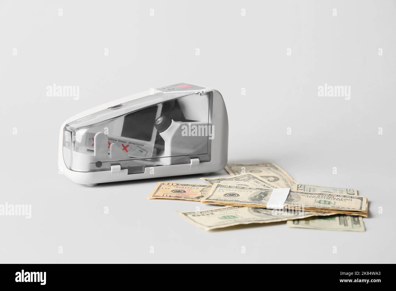 Modern currency counting machine and dollars on light background Stock ...