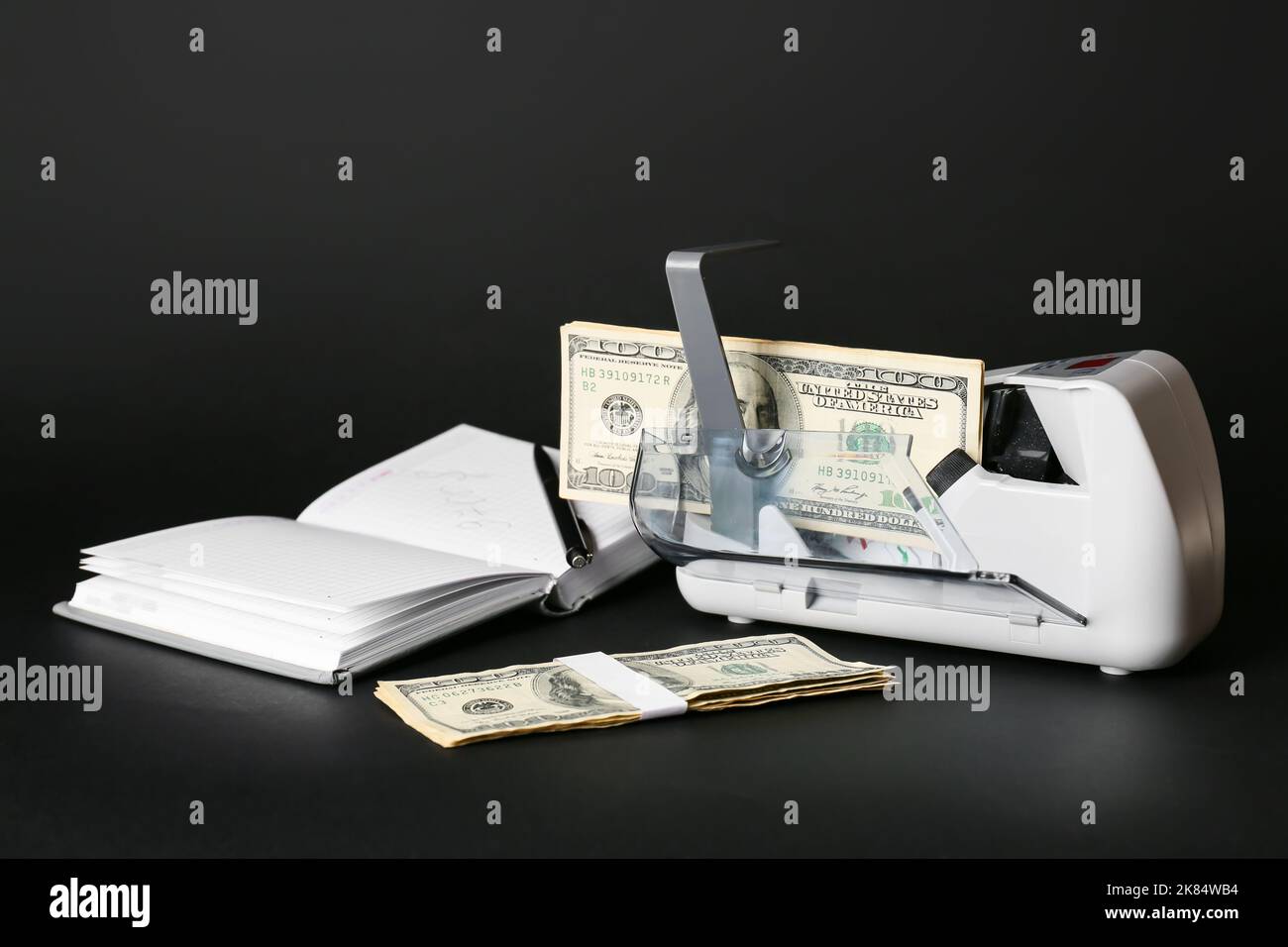 Counting machine with money and notebook on dark background Stock Photo ...