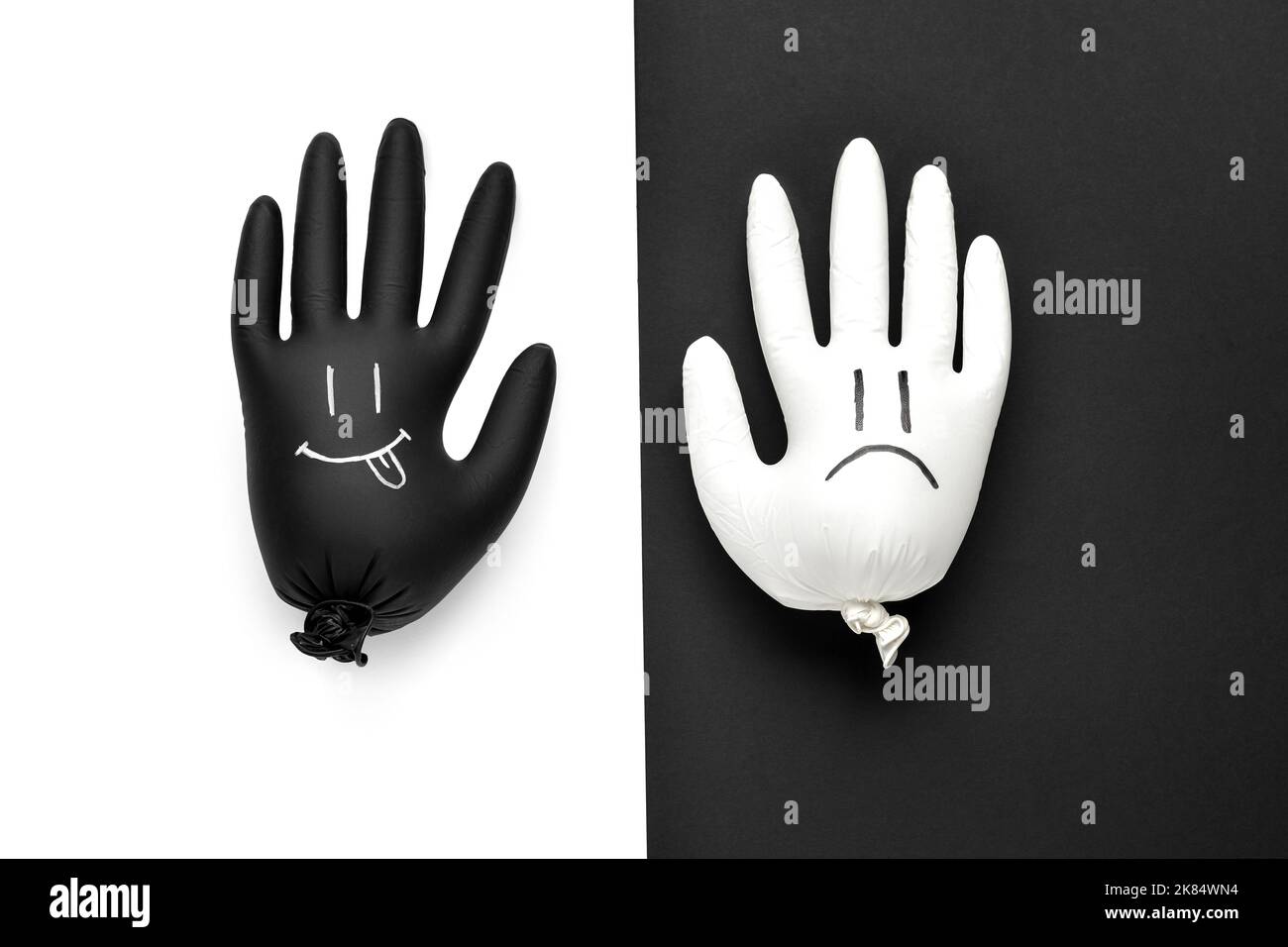 Different inflated gloves with sad and happy smiles on black and white ...