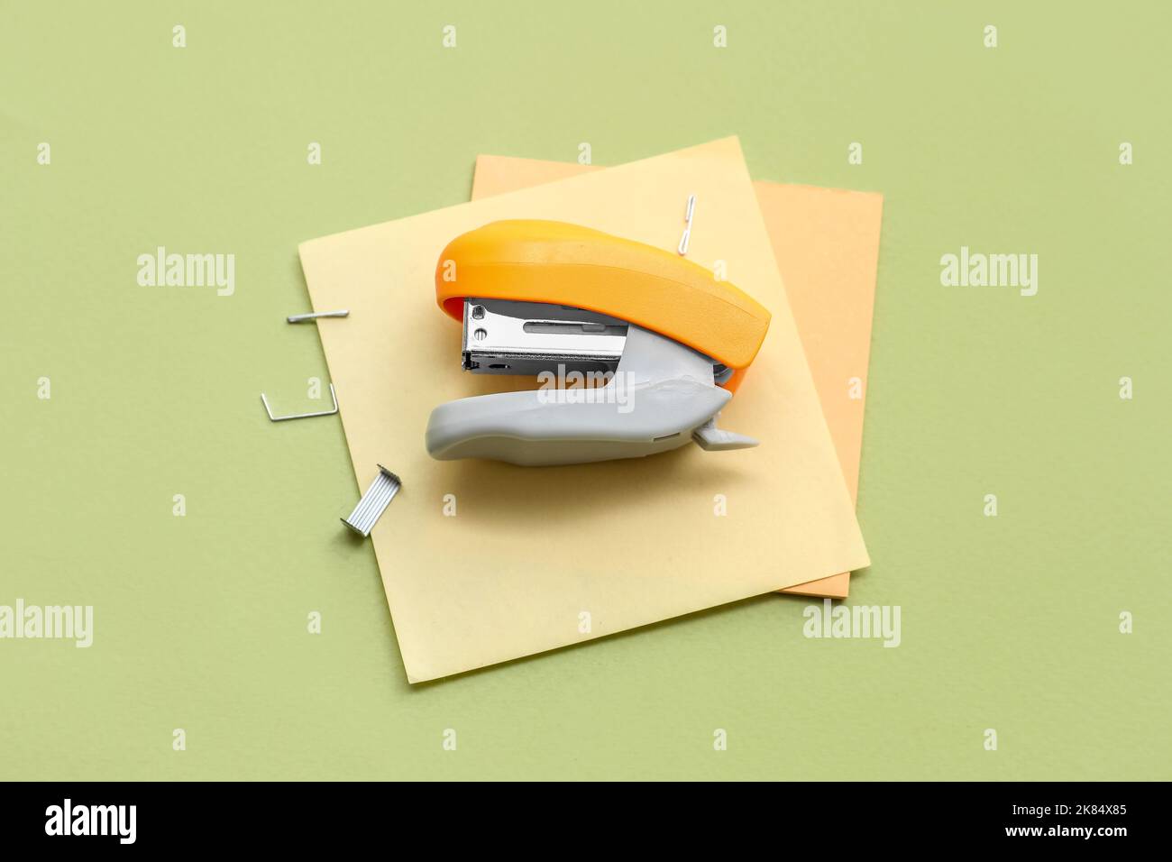 Stapler, sticky notes and staples on color background Stock Photo - Alamy