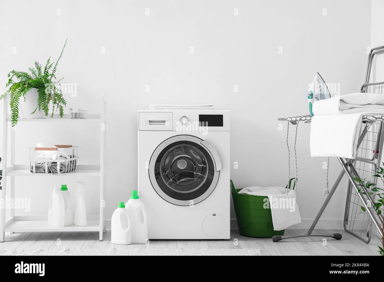 Interior of light laundry room with washing machine, shelving unit and ...
