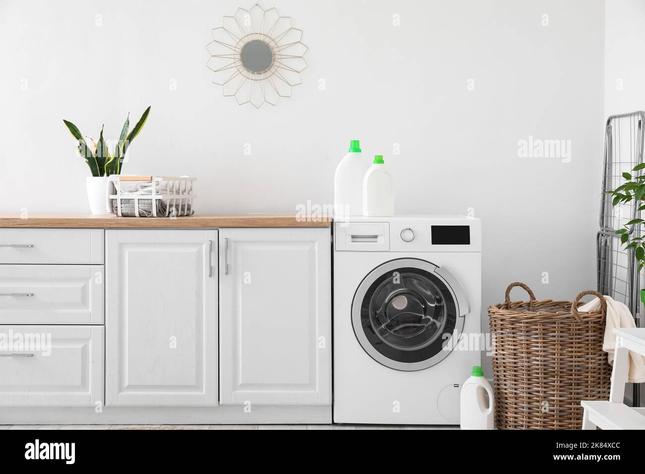 Interior of light laundry room with washing machine, counters and ...