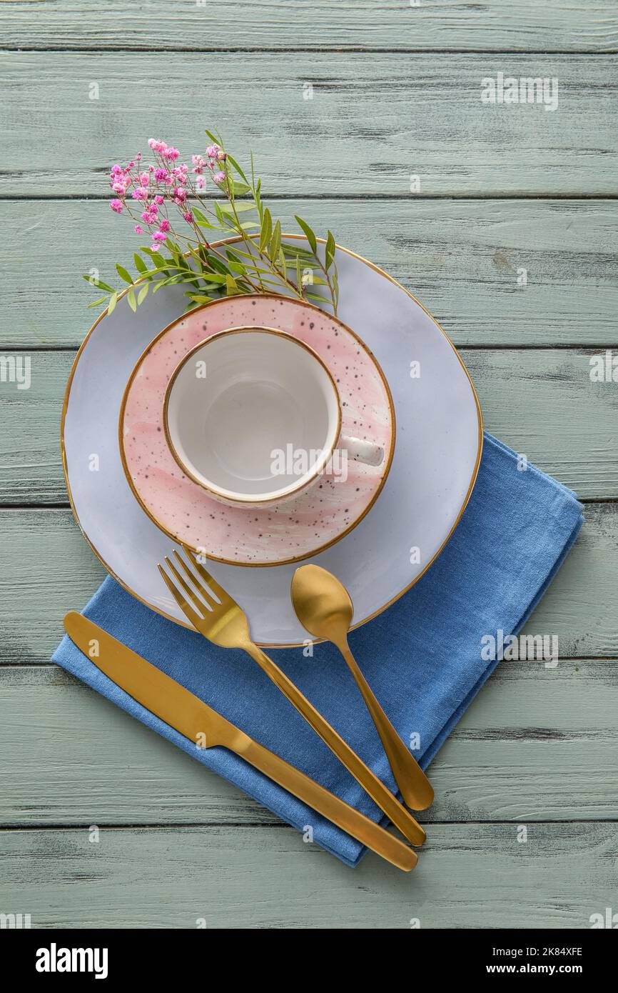 Stylish table setting with porcelain cup and cutlery on color wooden ...