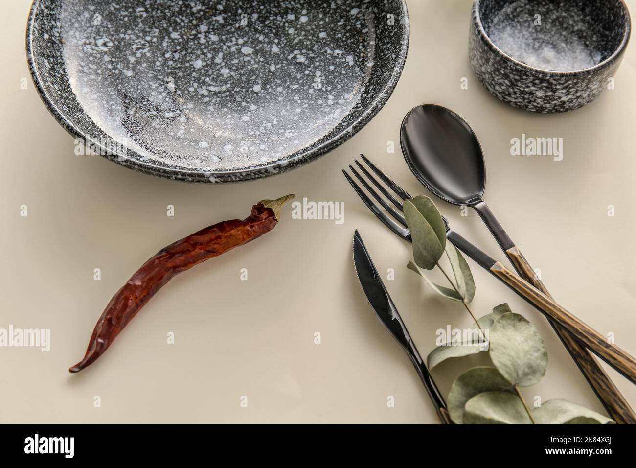 Table setting with hot chili pepper and eucalyptus branch on light ...