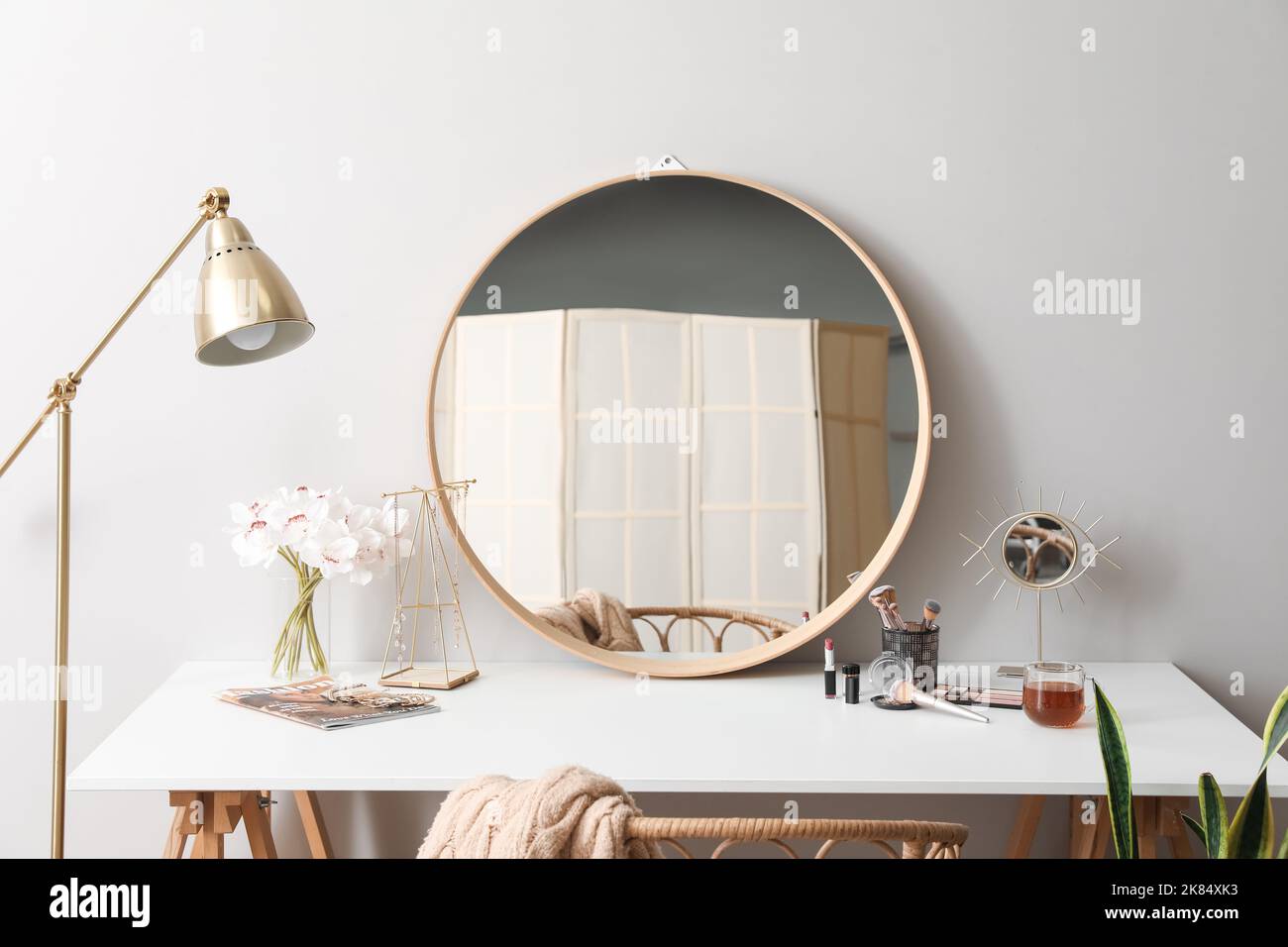 Dressing table with mirrors, flowers in vase, jewelry and cosmetics ...