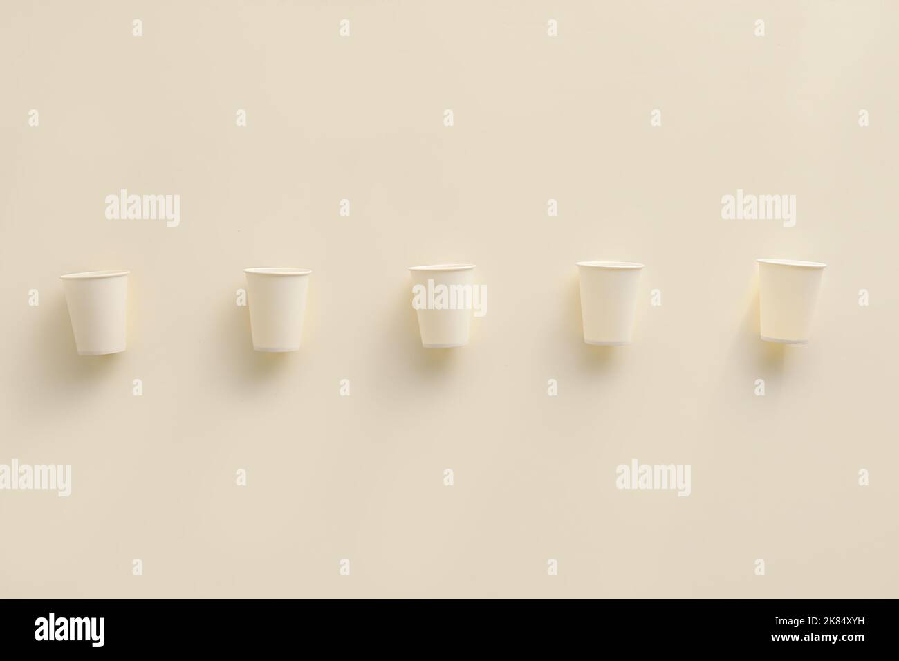 Row of paper cups on white background Stock Photo - Alamy