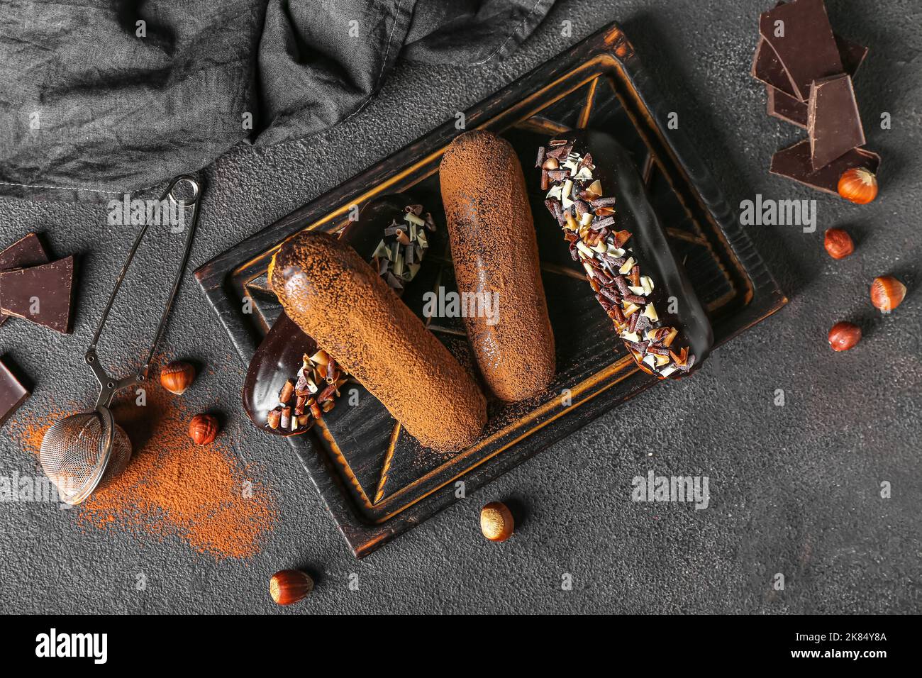 Wooden board with sweet chocolate eclairs on dark background Stock ...