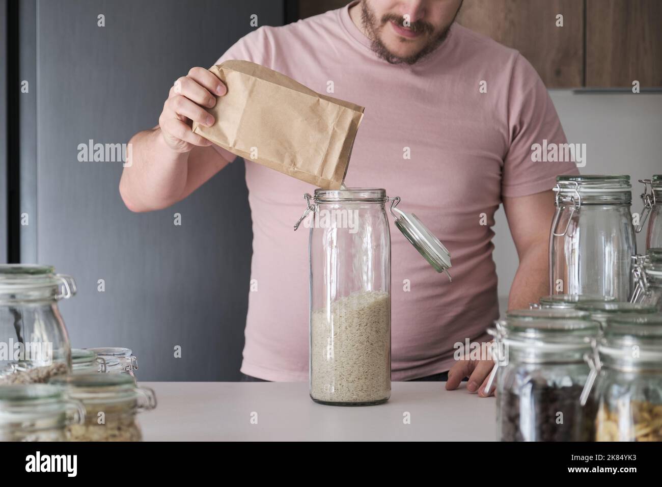 Unrecognizable latin man filling up a jar with basmati rice from a ...