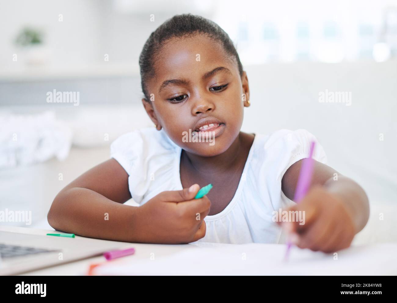 These pictures need to be perfect. a little girl writing in a book at ...