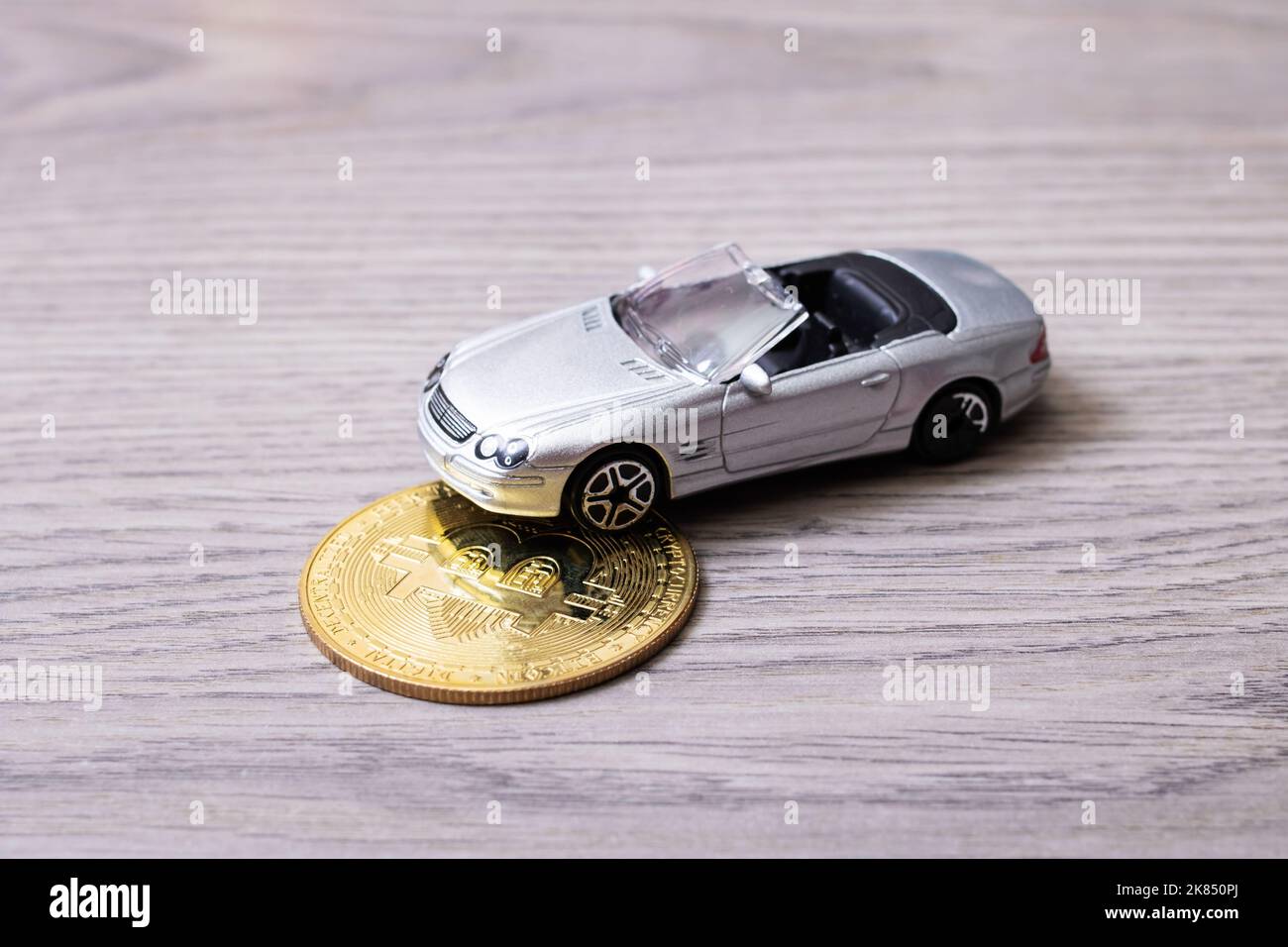 Bitcoin and toy car on wooden background Stock Photo - Alamy